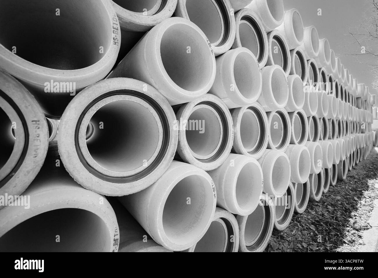 Rows of concrete pipes with a wide-angle look in black and white high ...