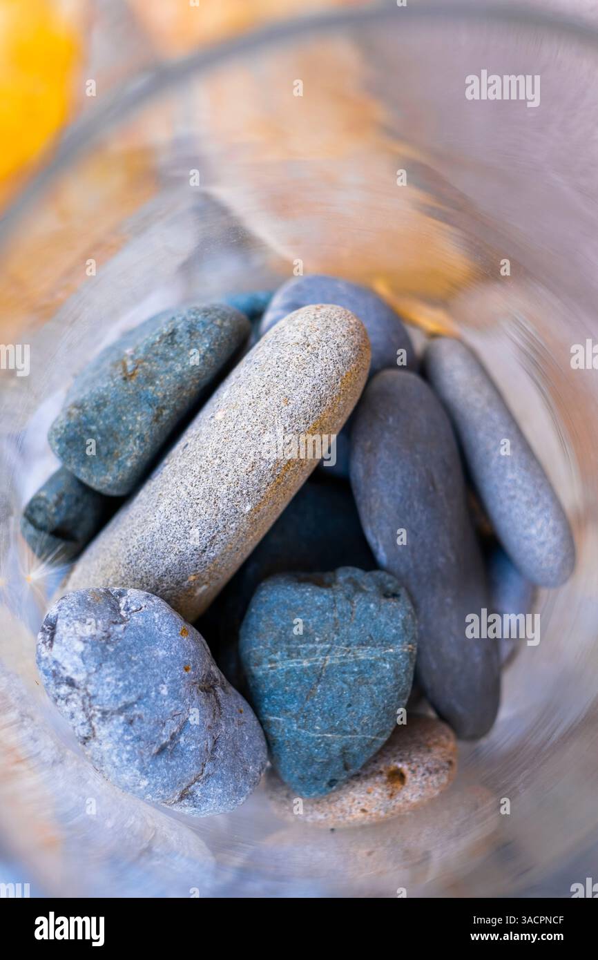 Glass filled with decorative river rocks creating soothing atmosphere ...