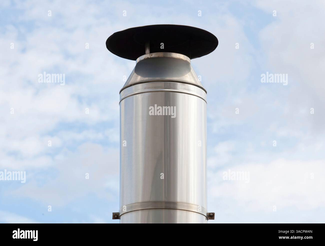 Shiny metal chimney pipe with anti rain cap, releasing polluting fumes ...