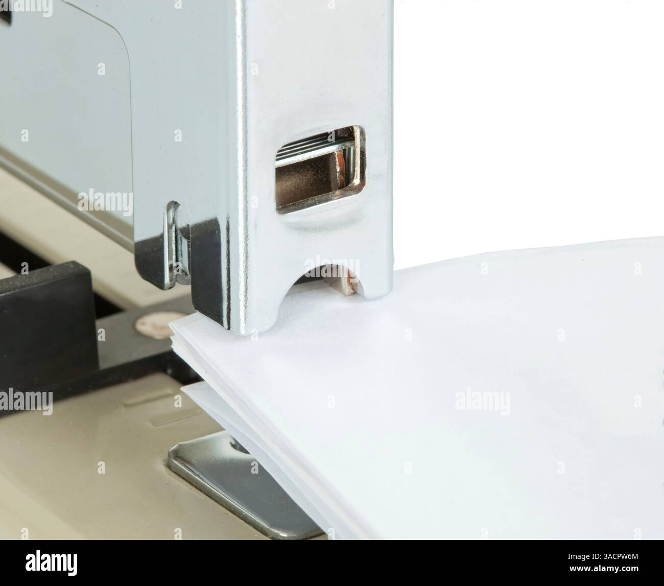 Metallic stapler binding sheets of white paper on white background ...