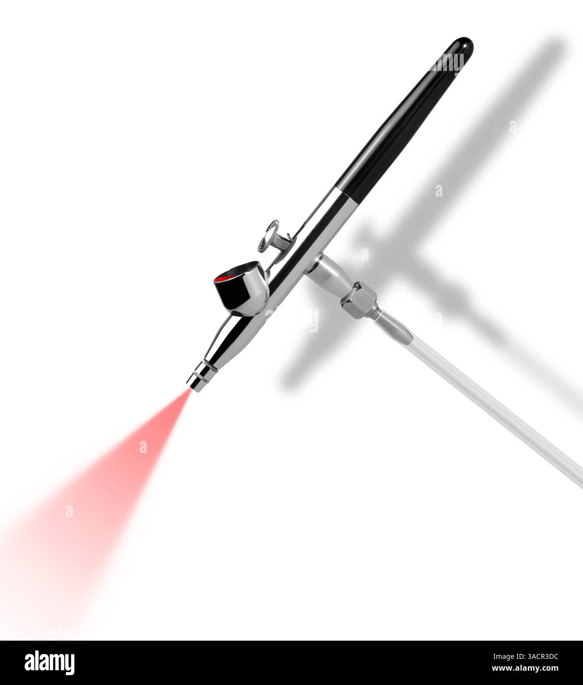Airbrush pistol spraying red paint, isolated on white background with ...