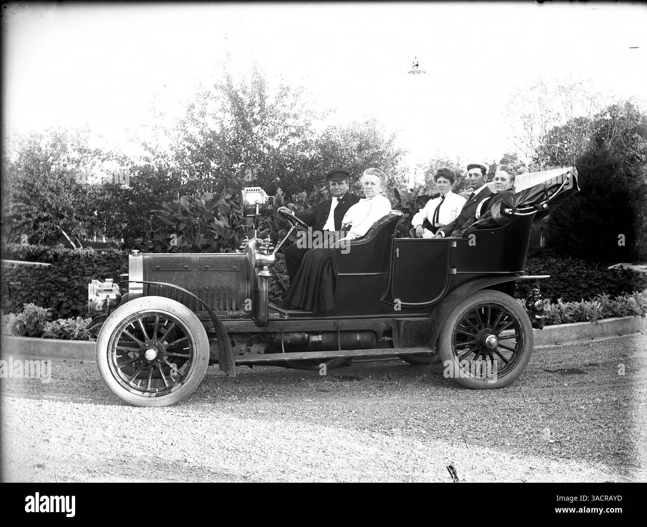 The J.F. Wilcox family and George Rose are pictured in an automobile ...