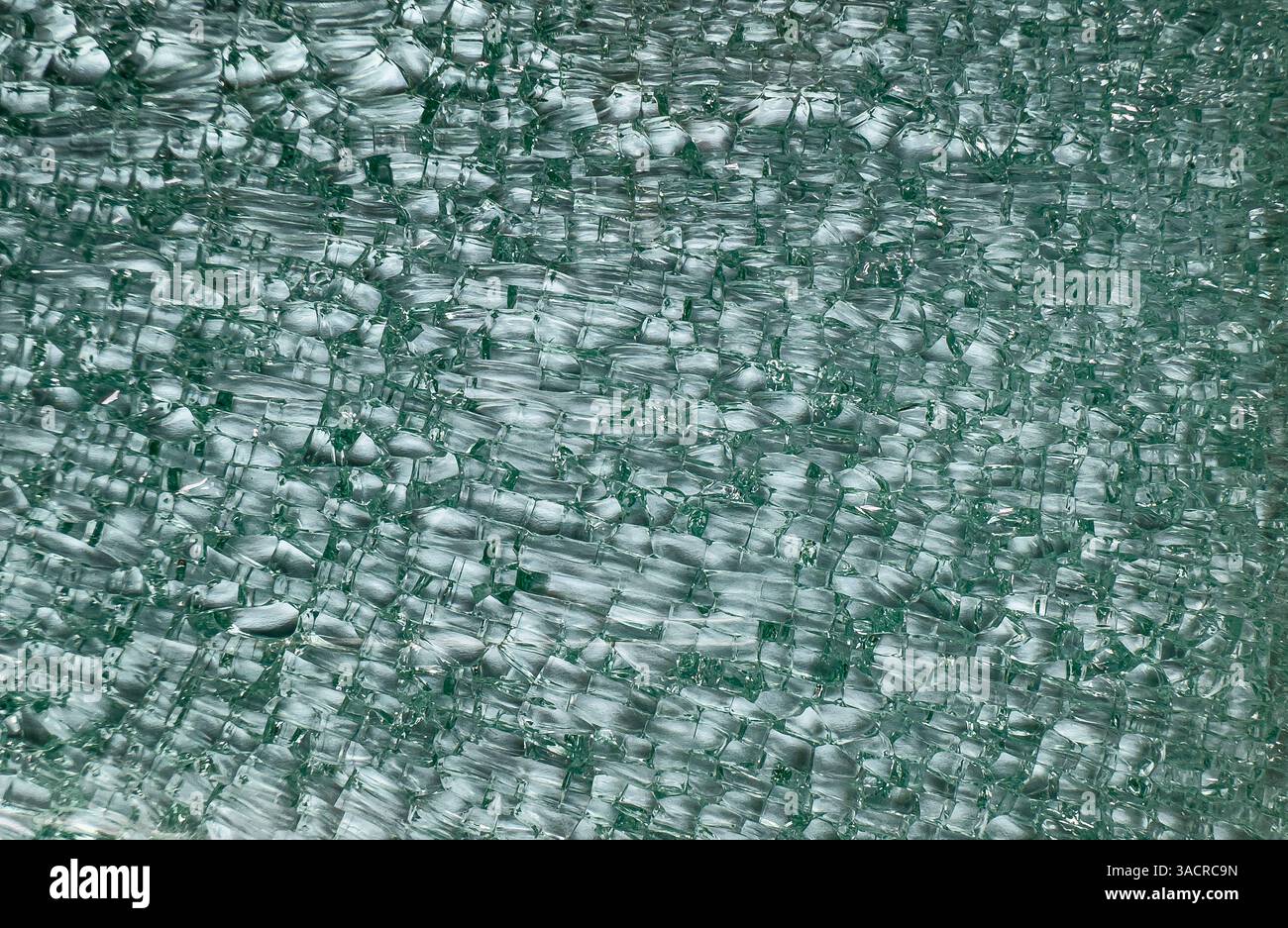 Shattered glass fragments with a green tint, forming an intricate ...