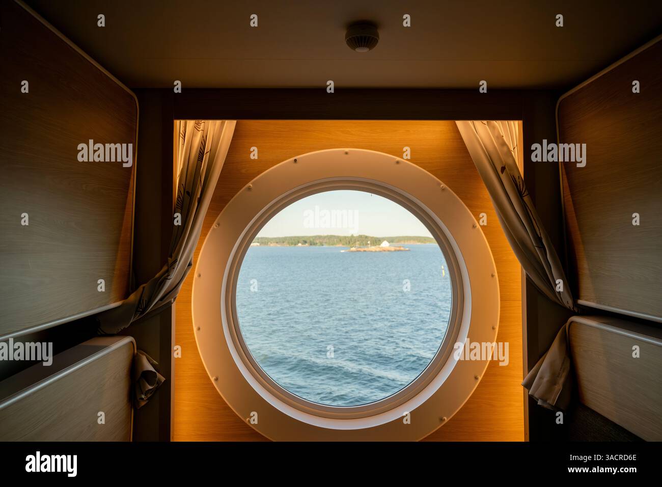 Scenic sea view through porthole from cozy cruise ship cabin interior ...