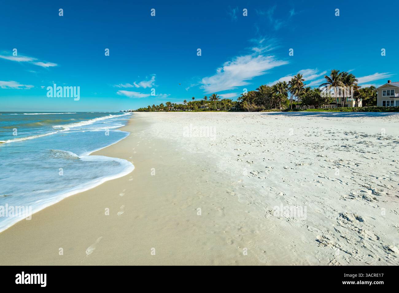 A serene beach in Naples, Florida features soft white sand, gentle ...