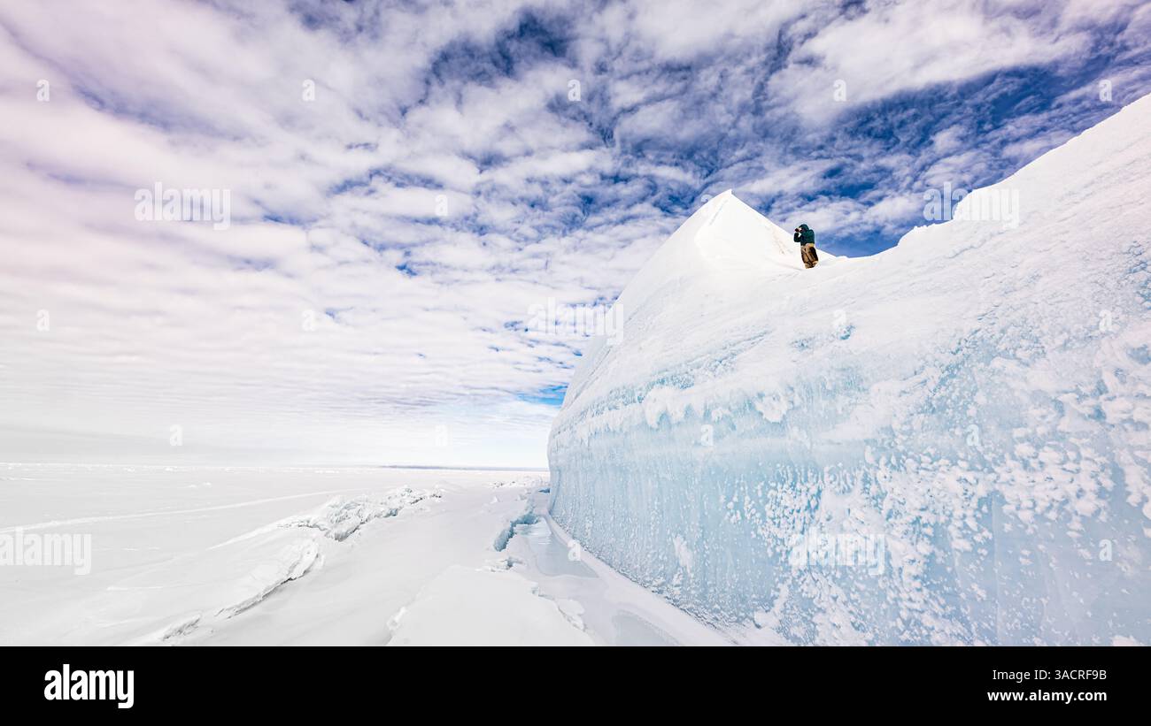 Anonymous Inuit guide with binoculars searching for polar bears rom the ...