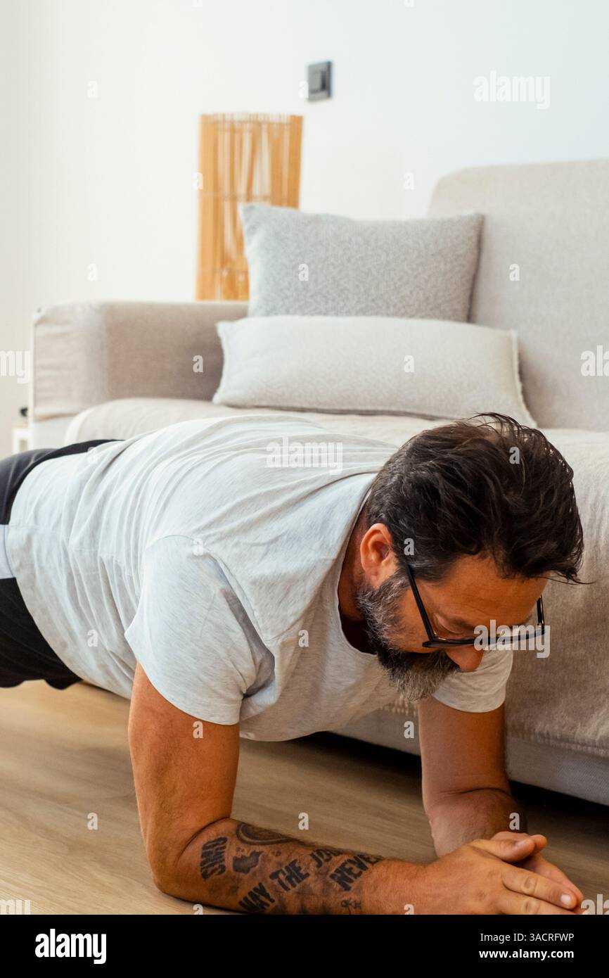 A middle-aged man performing a daily fitness routine at home, using ...