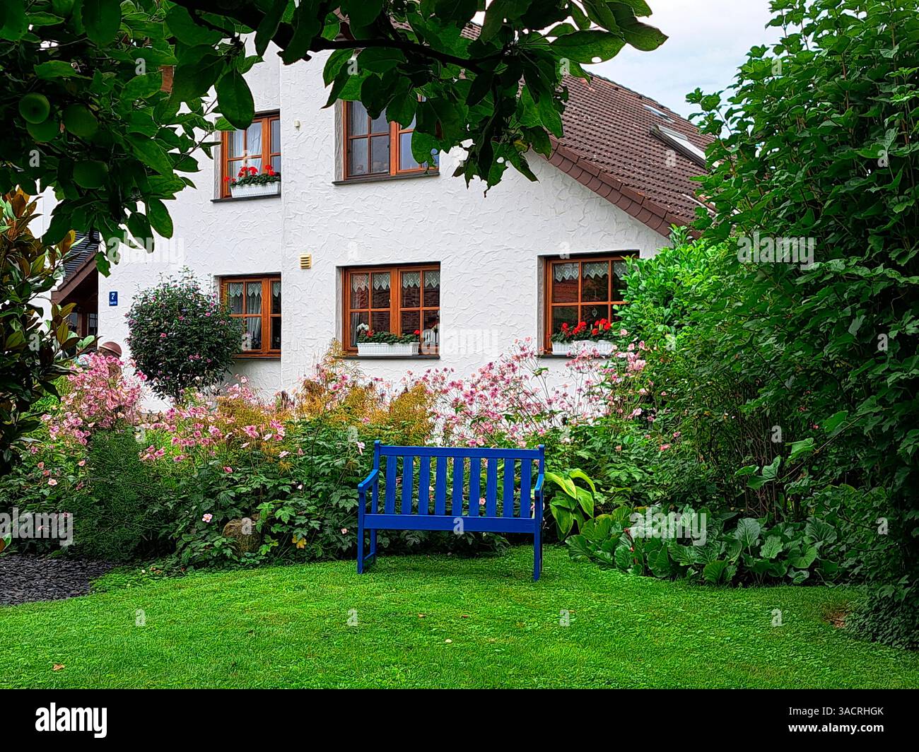Blue bench in front of a country-style detached house Stock Photo - Alamy