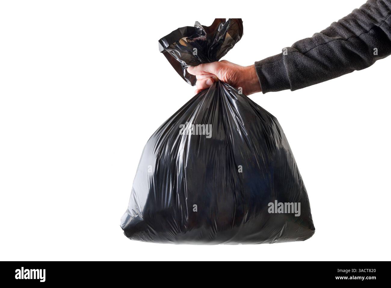 Detail of a person's hand throwing away a black plastic bag full of ...