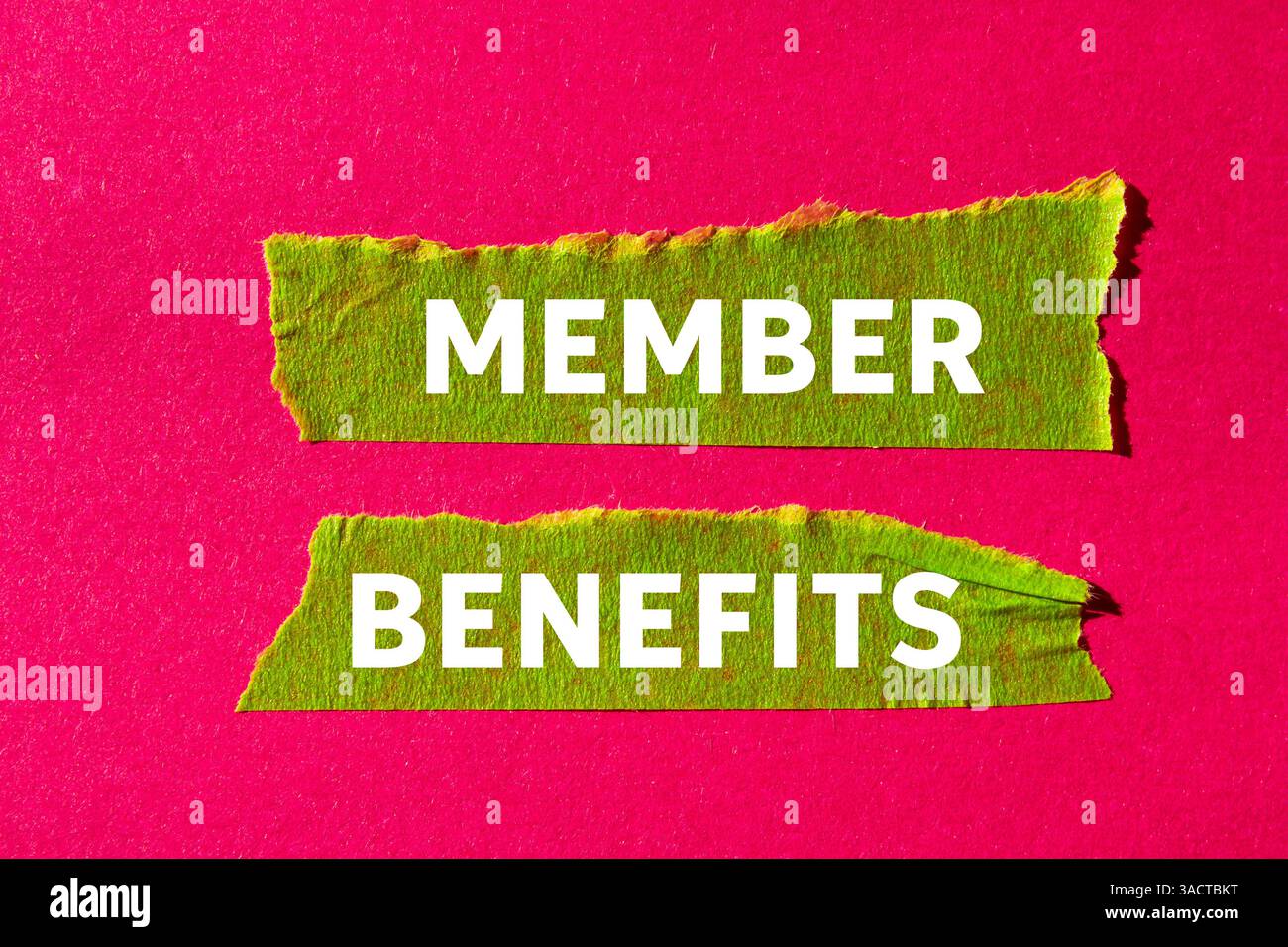 Member benefits message written on ripped torn green paper tape on pink background. Conceptual ...