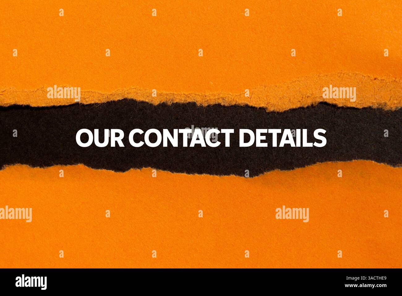 Our contact details message written on ripped torn orange paper on black background. Conceptual ...