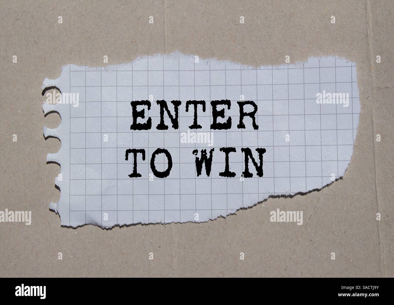 Enter to win message written on ripped torn paper piece on paper ...