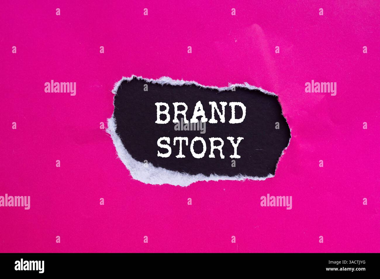 Brand story message written on ripped torn pink paper on black ...