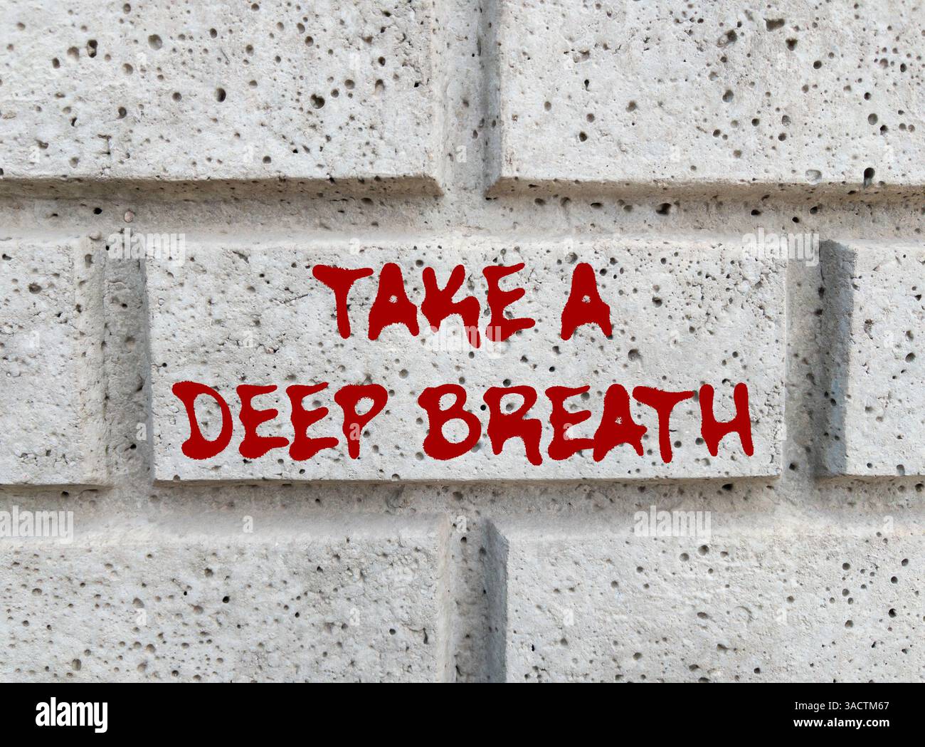 Take a deep breath message written on gray stone wall. Conceptual take ...