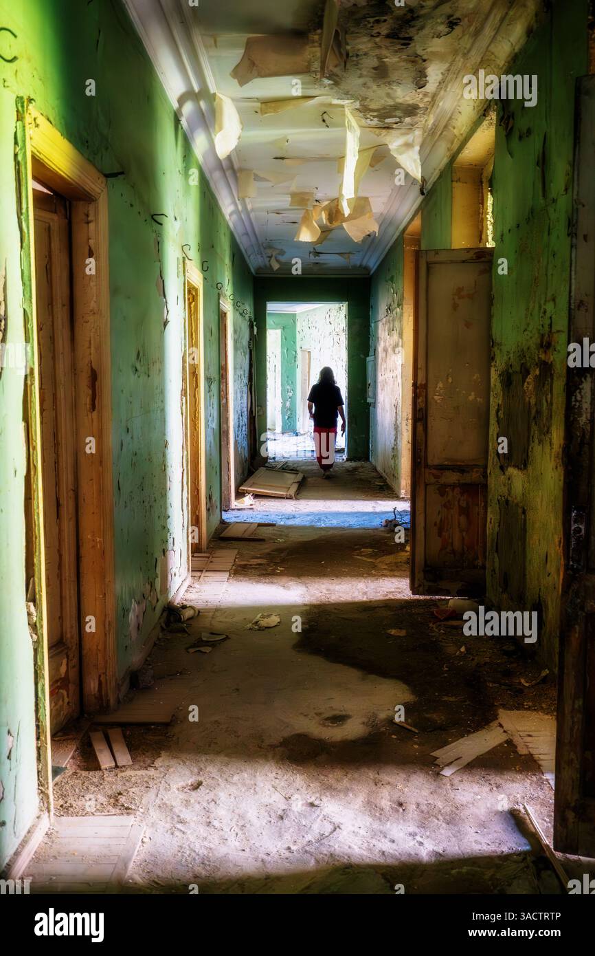 Abandoned building hallway with woman silhouette, urban exploration, mental health, loneliness ...