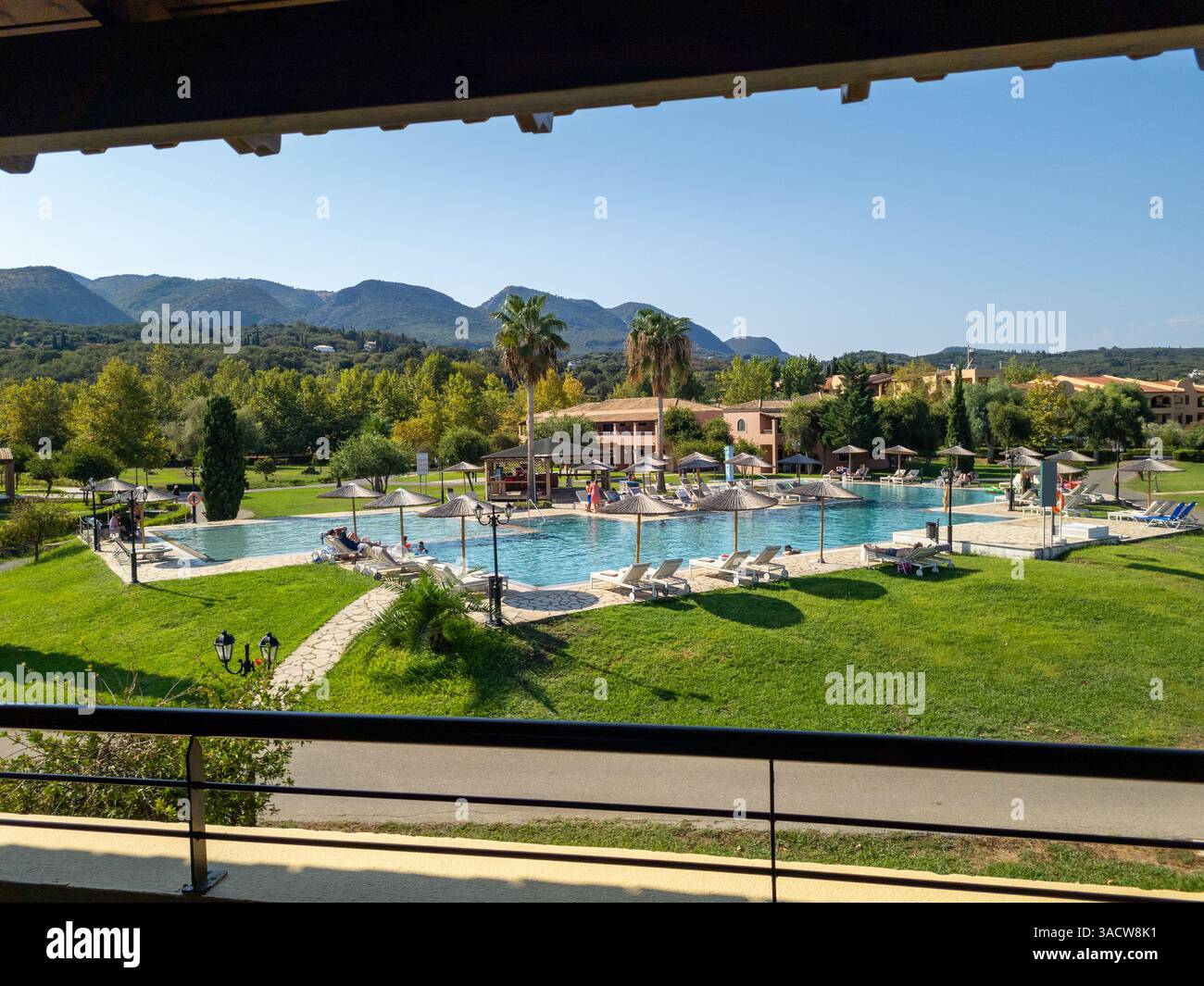 Scenic resort view overlooking a large pool with lush greenery ...