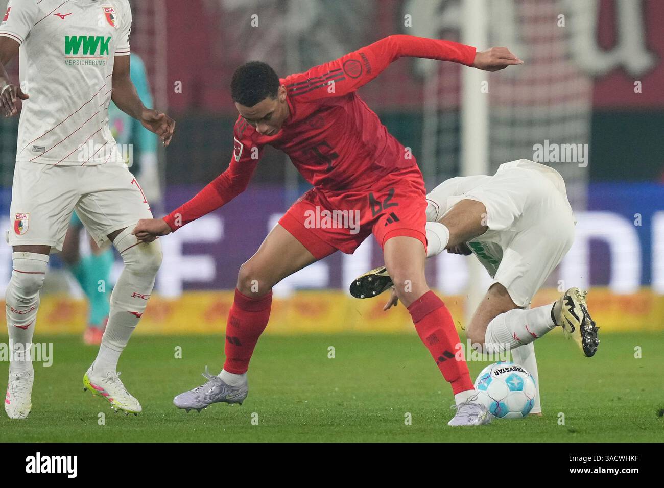 Augsburg's Alexis Claude Maurice falls by Bayern's Jamal Musiala during ...