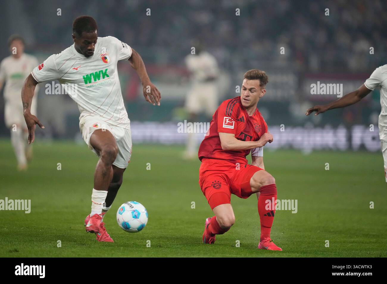 Augsburg's Samuel Essende in action by Bayern's Joshua Kimmich during ...