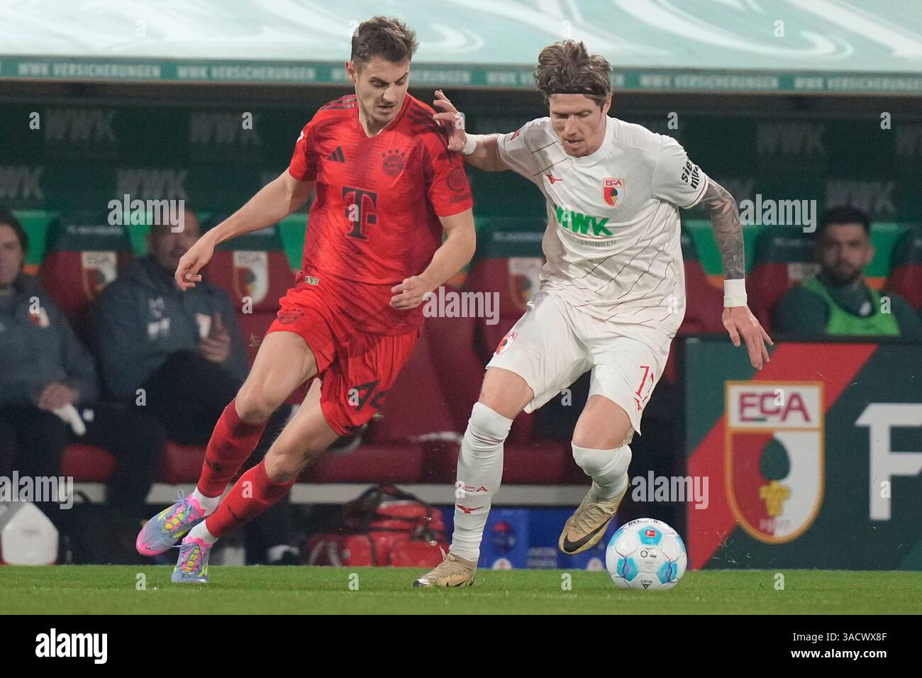 Bayern's Josip Stanisic, left, and Augsburg's Kristijan Jakic fight for ...