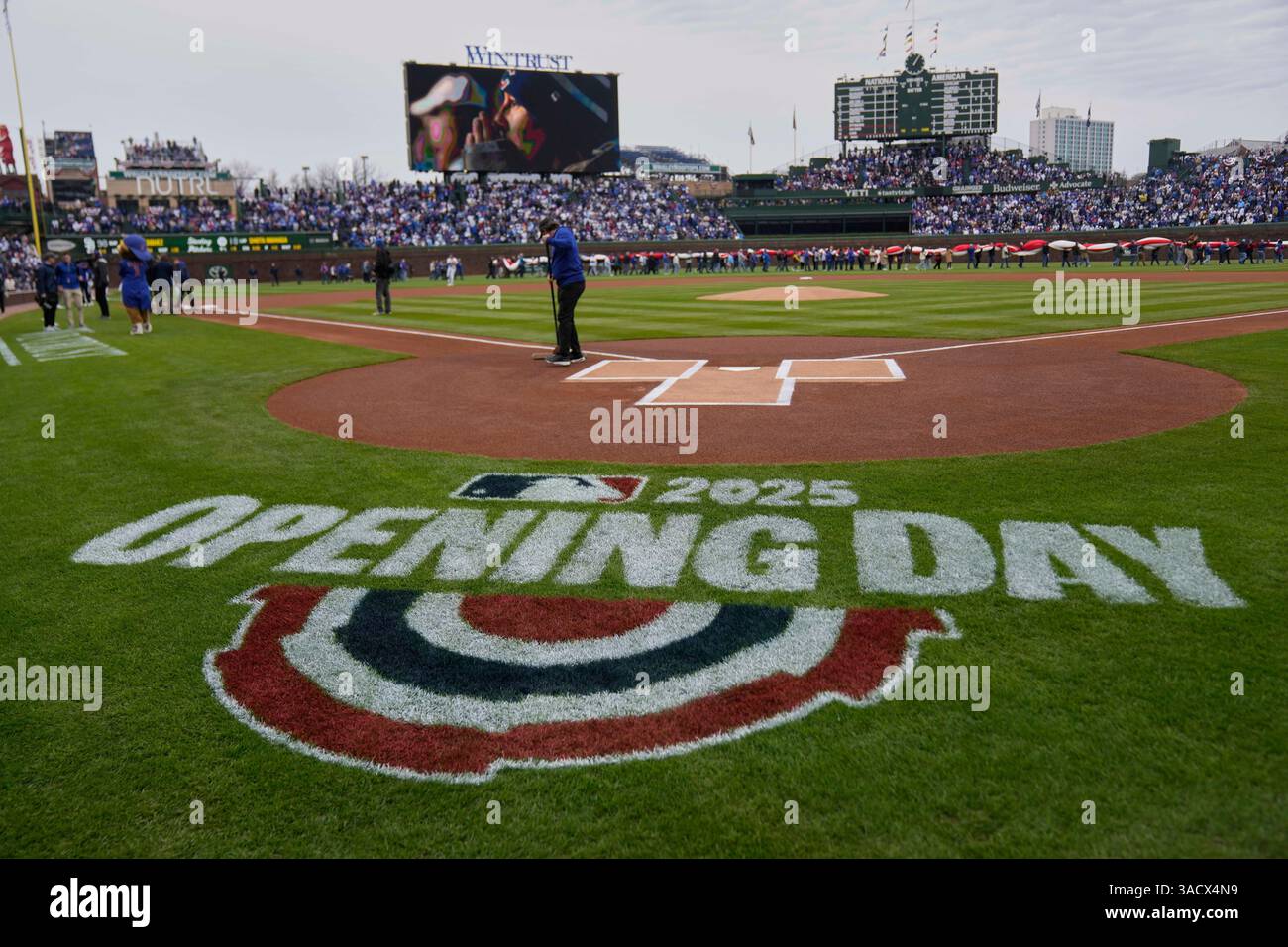 Grounds crew members work on the field before a baseball game between ...