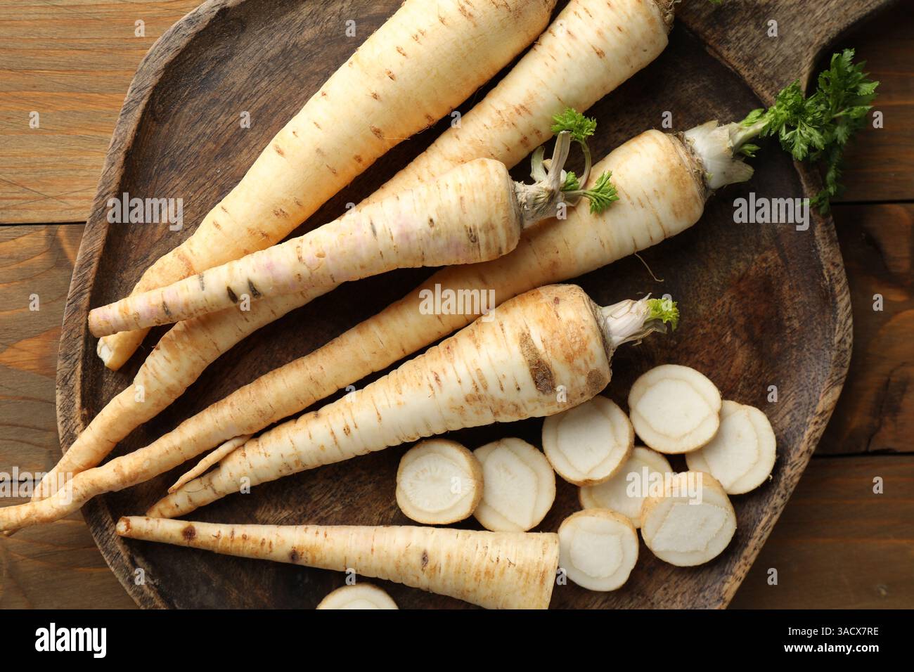 Whole and cut fresh parsley roots on wooden table, top view Stock Photo ...