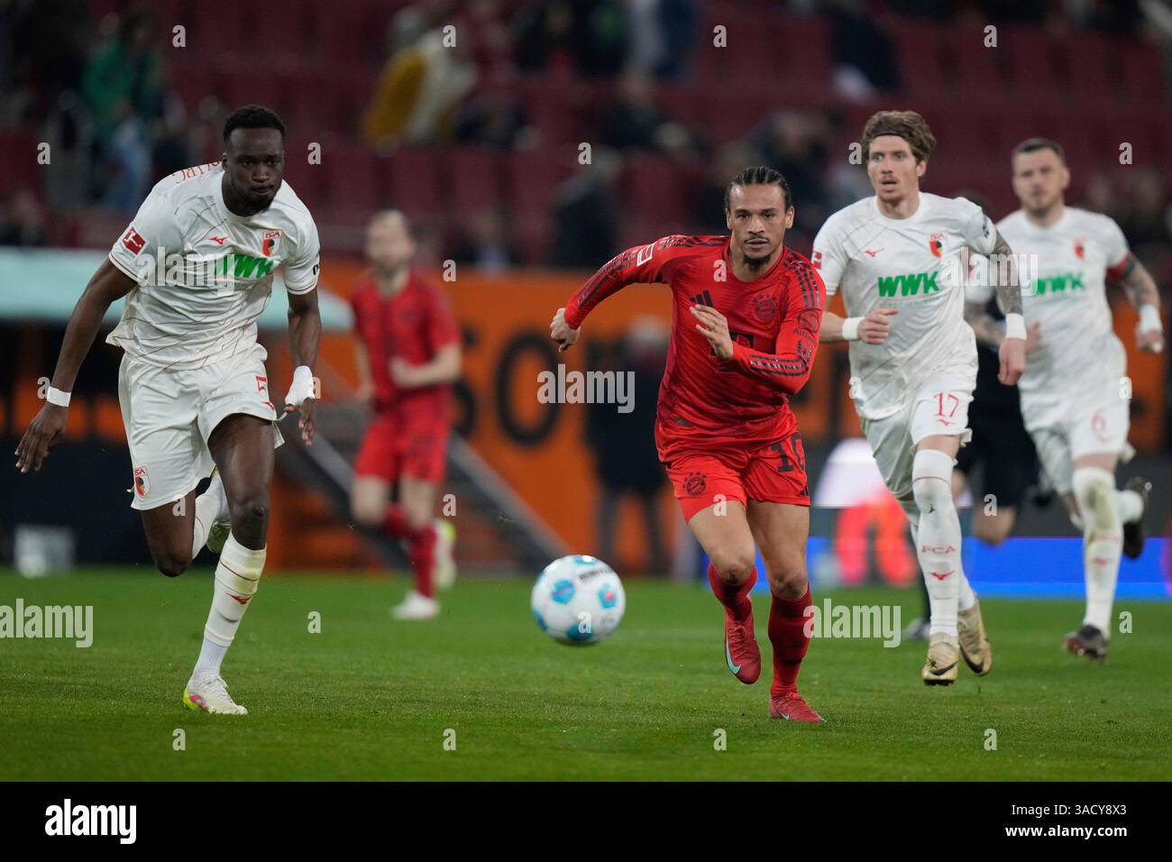 Augsburg's Chrislain Matsima, left, and Bayern's Leroy Sane run for the ...