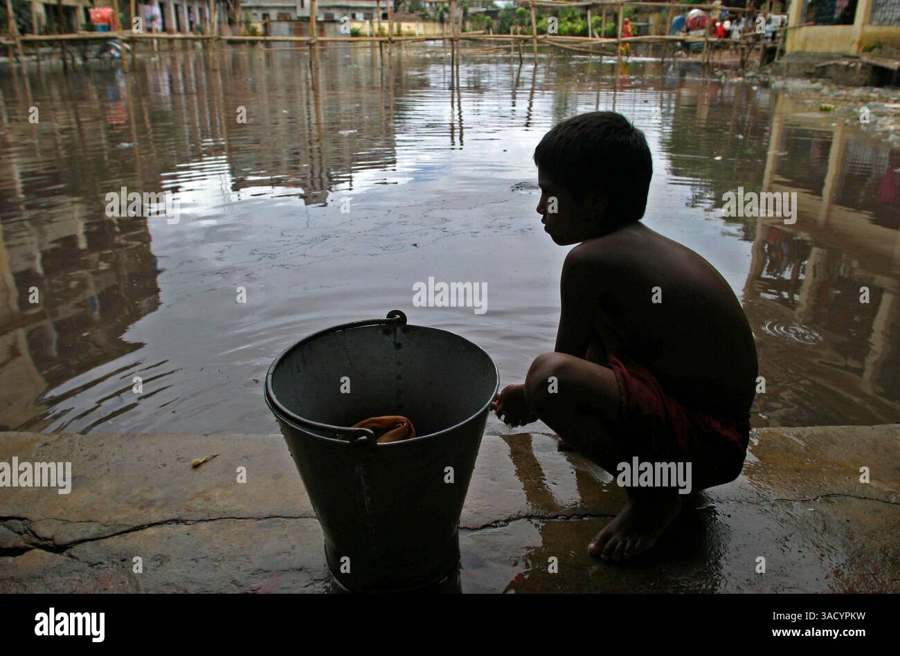 Aug 12, 2004; Dhaka, BANGLADESH; A child washes clothes in polluted ...