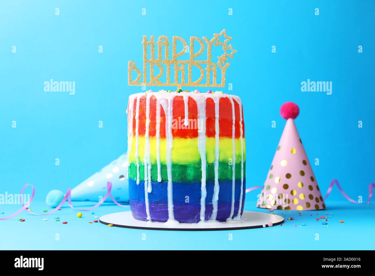 Delicious rainbow birthday cake with topper, sprinkles and party hats ...