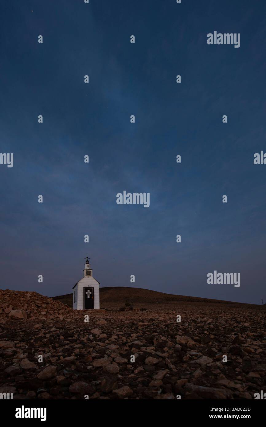 Small white wooden chapel in a monotonous rocky volcanic landscape ...