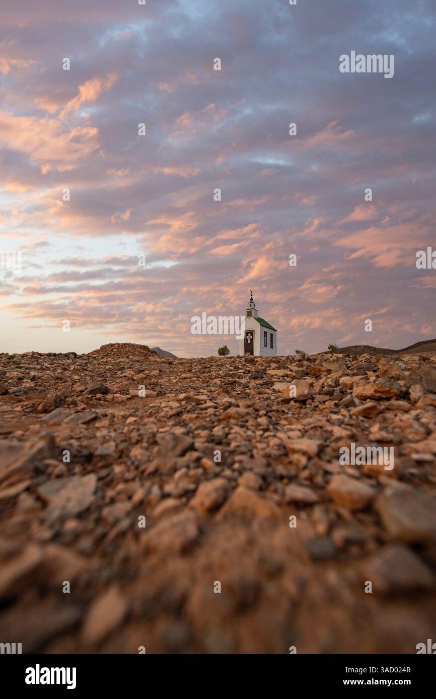 Small white wooden chapel in a barren volcanic landscape. Sunrise ...
