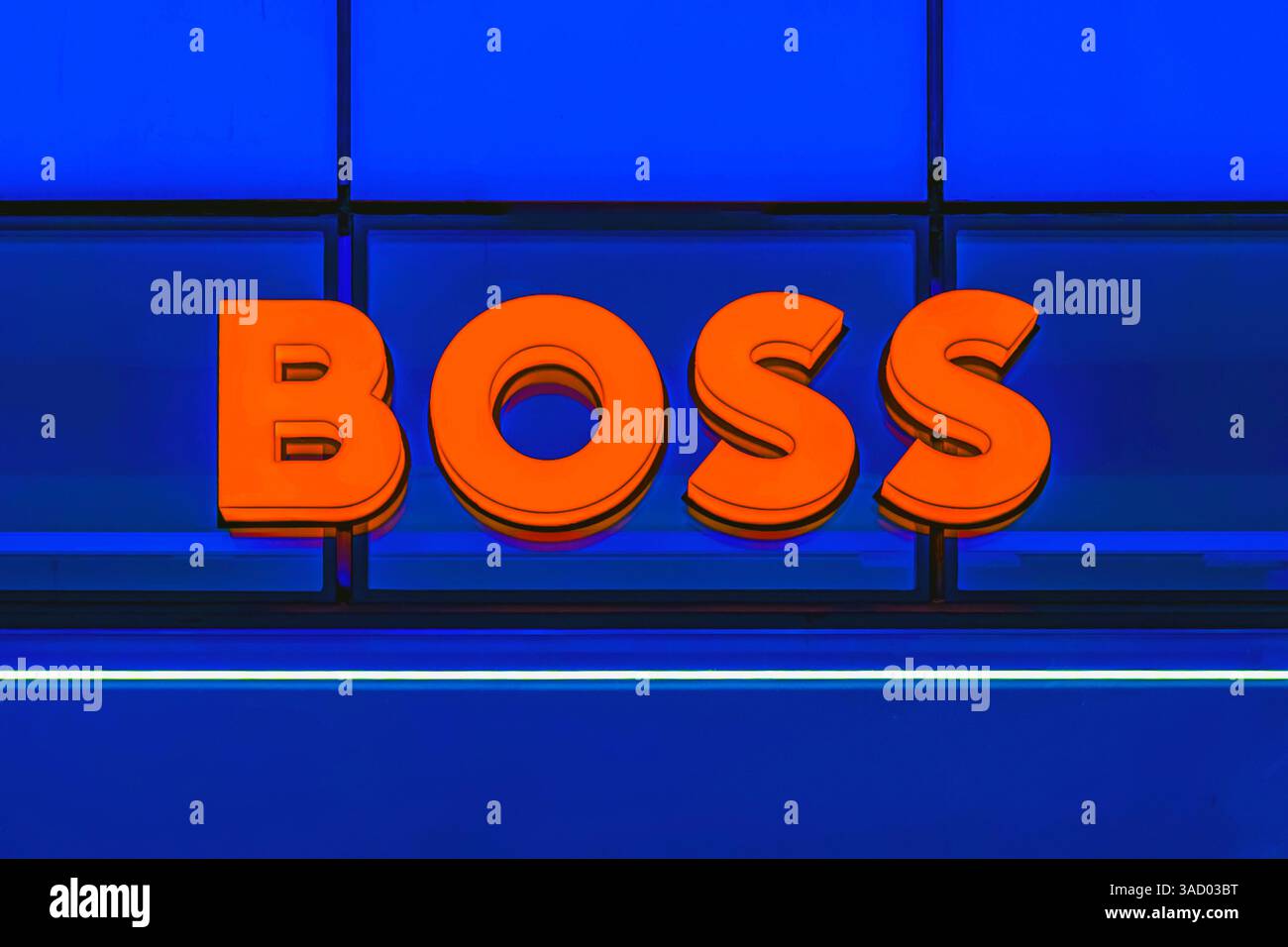 Bright orange BOSS store sign with bold letters on deep blue glass wall ...