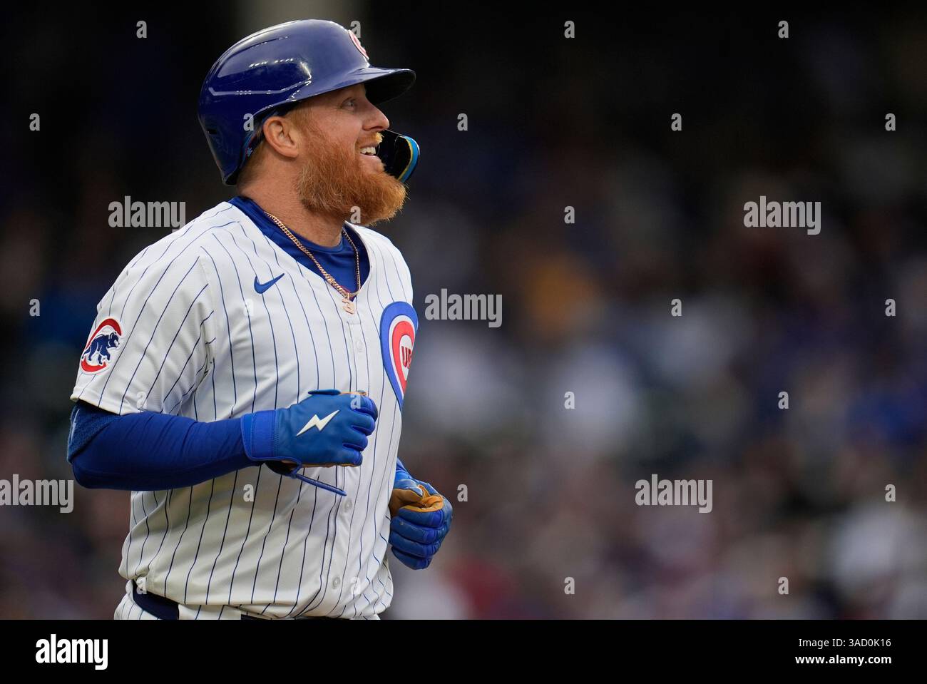Chicago Cubs' Justin Turner jogs to first base after getting hit with a ...