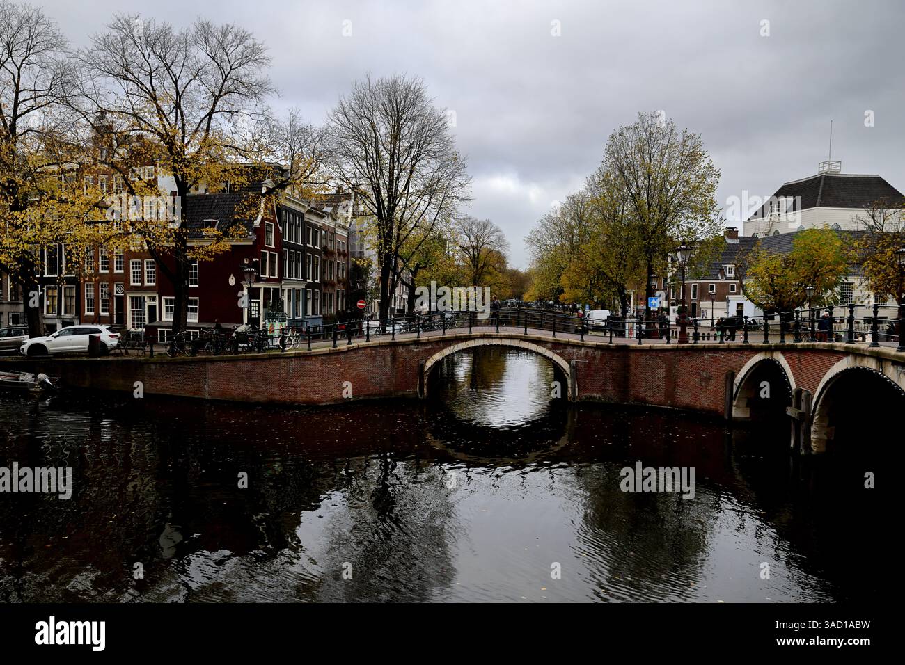 An iconic Amsterdam canal with a brick bridge, traditional Dutch gabled ...