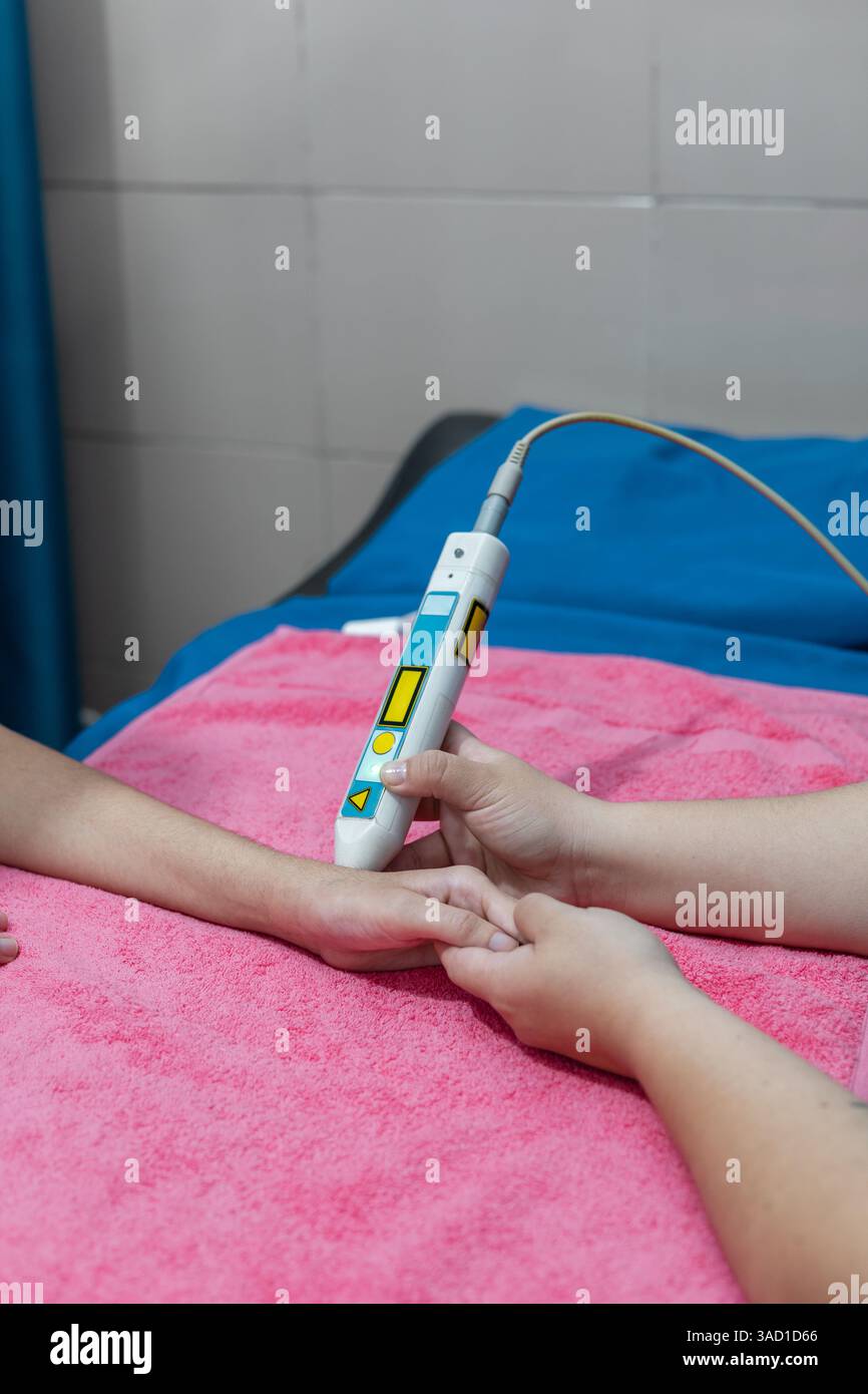 A patient is undergoing ultrasound therapy on their arm to relieve pain ...