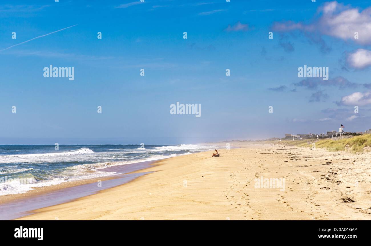 summer landscape of an amagansett beach with a single person sitting on ...