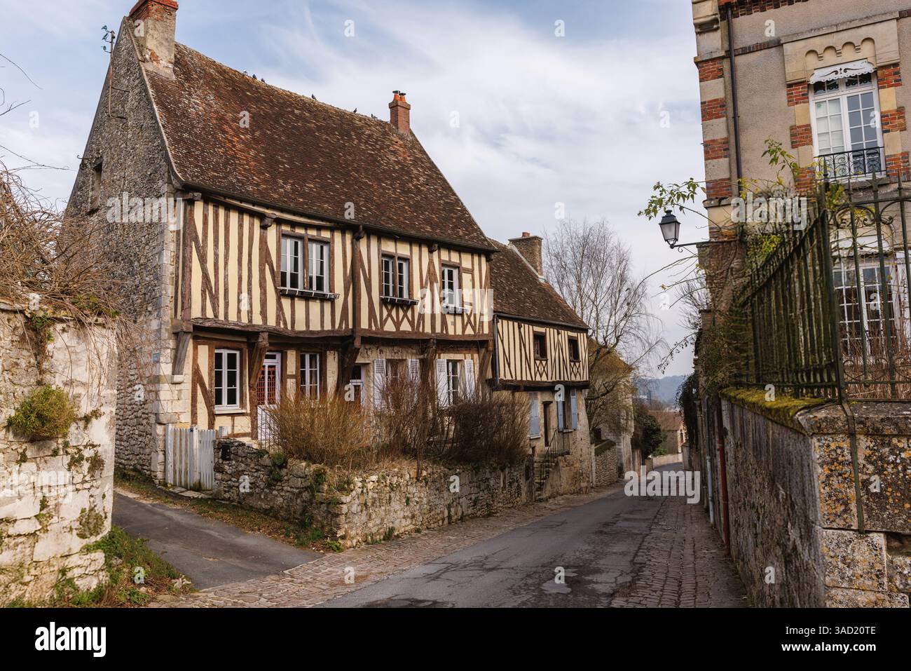 A small house with a stone wall and a stone path. French medieval town ...