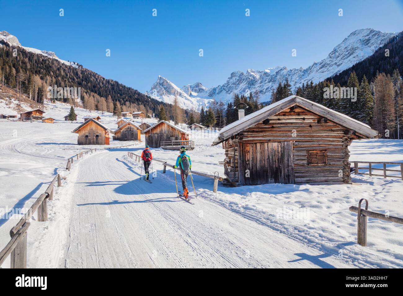 Small alpine village in Val San Nicolò, two ski mountaineers go up the ...