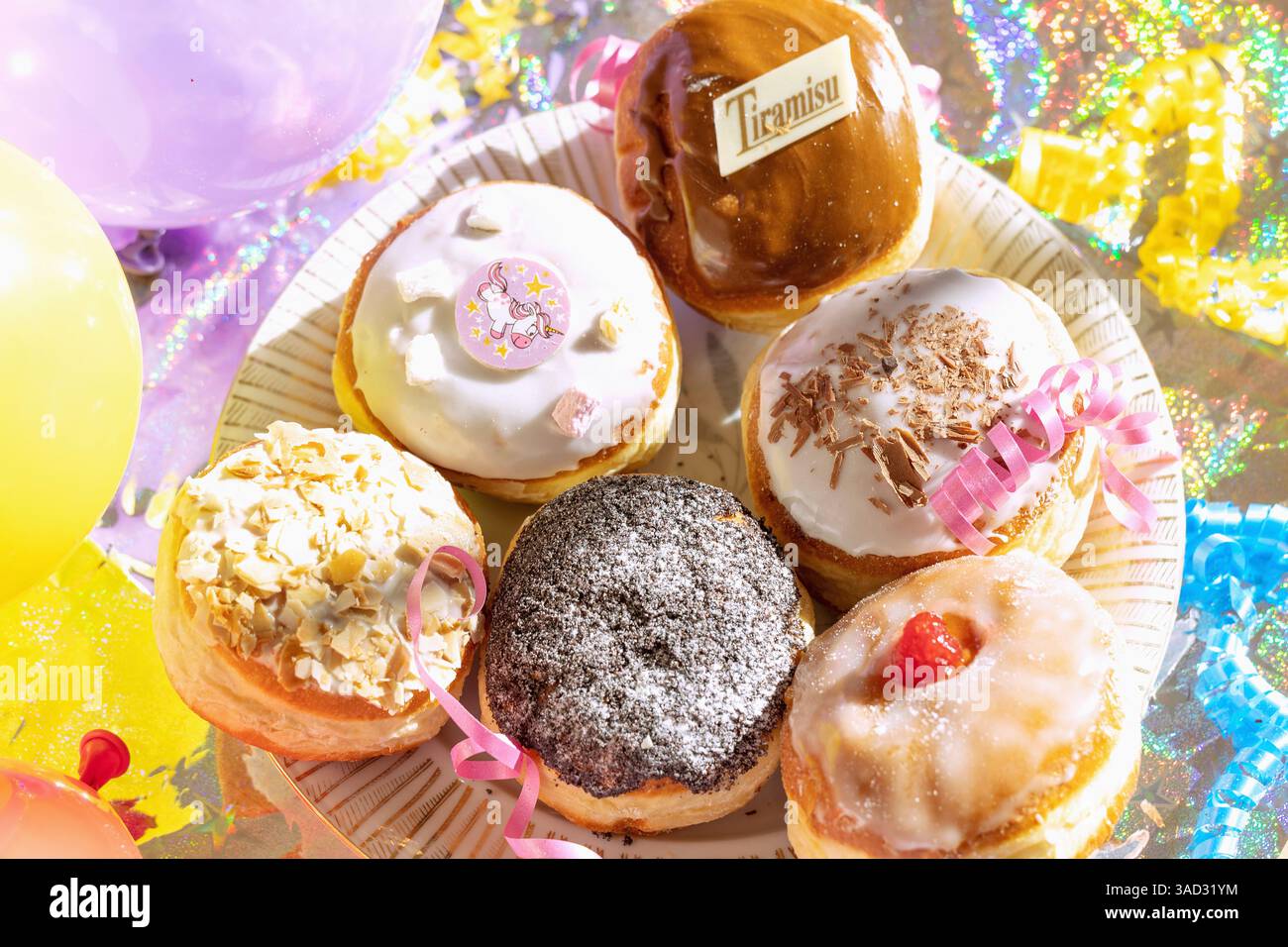 Colorful carnival doughnuts with different glazes on a plate with ...