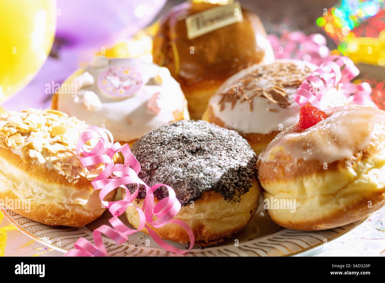 Colorful carnival doughnuts with different glazes on a plate with ...