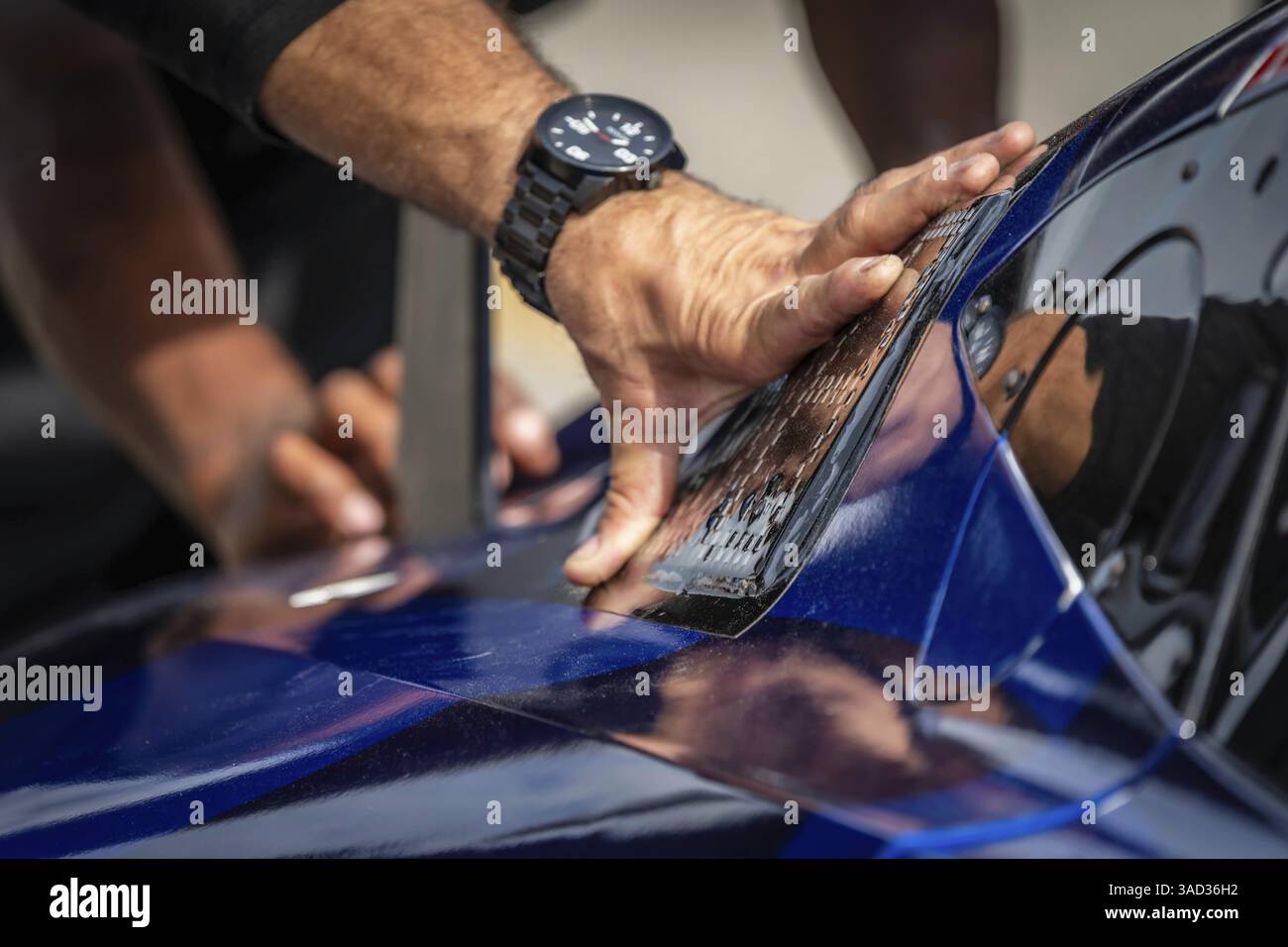 An engineer meticulously inspects the race car, fine-tuning key ...