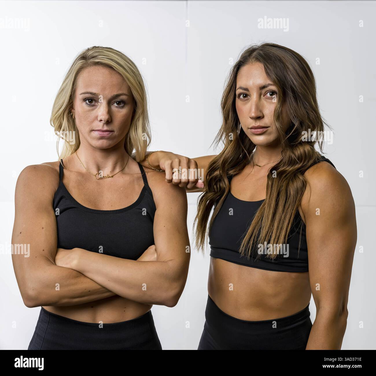 Two gorgeous athletic fit models pose confidently, their toned muscles ...