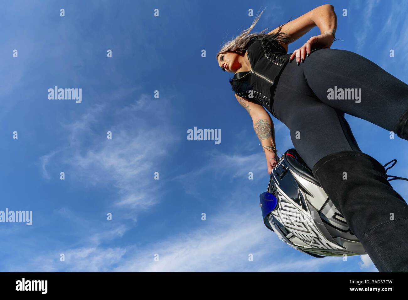 A stunning woman strikes a confident pose beside her high-performance ...