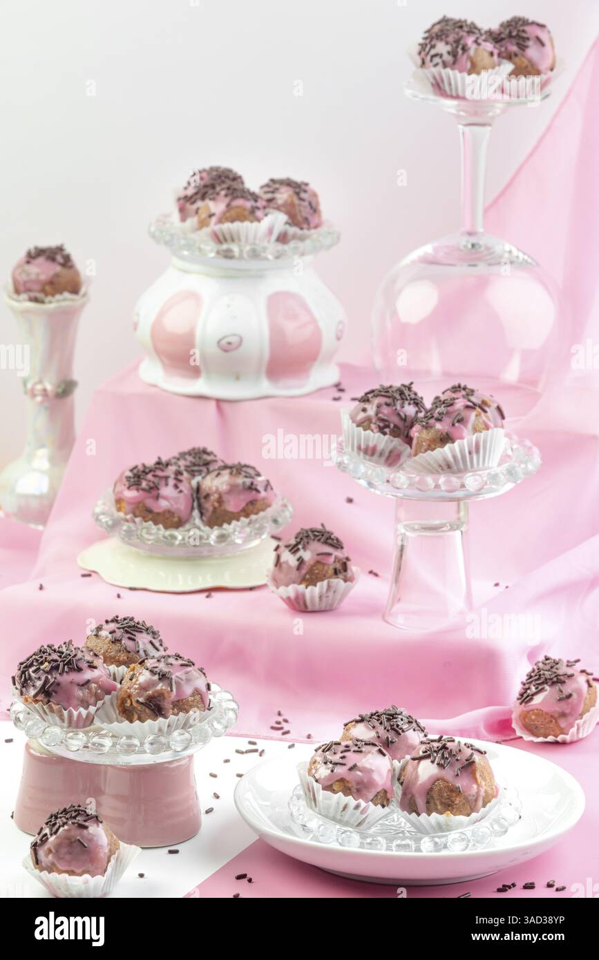 Punch balls, pink-coated chocolates on various glass plates with an ...