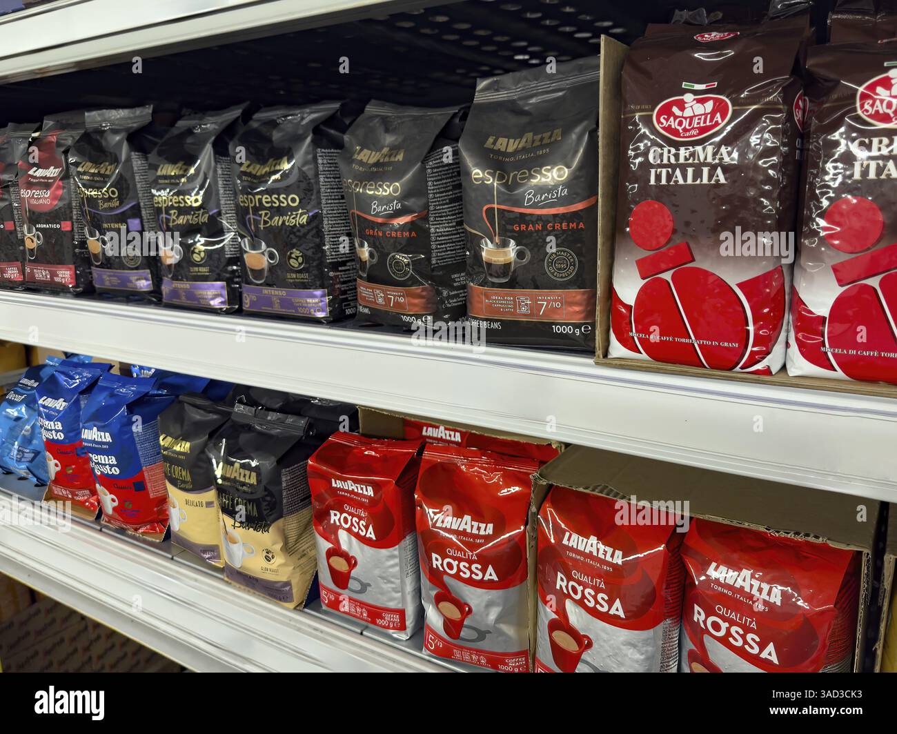 Display shelf with various types of packs of unground coffee beans ...