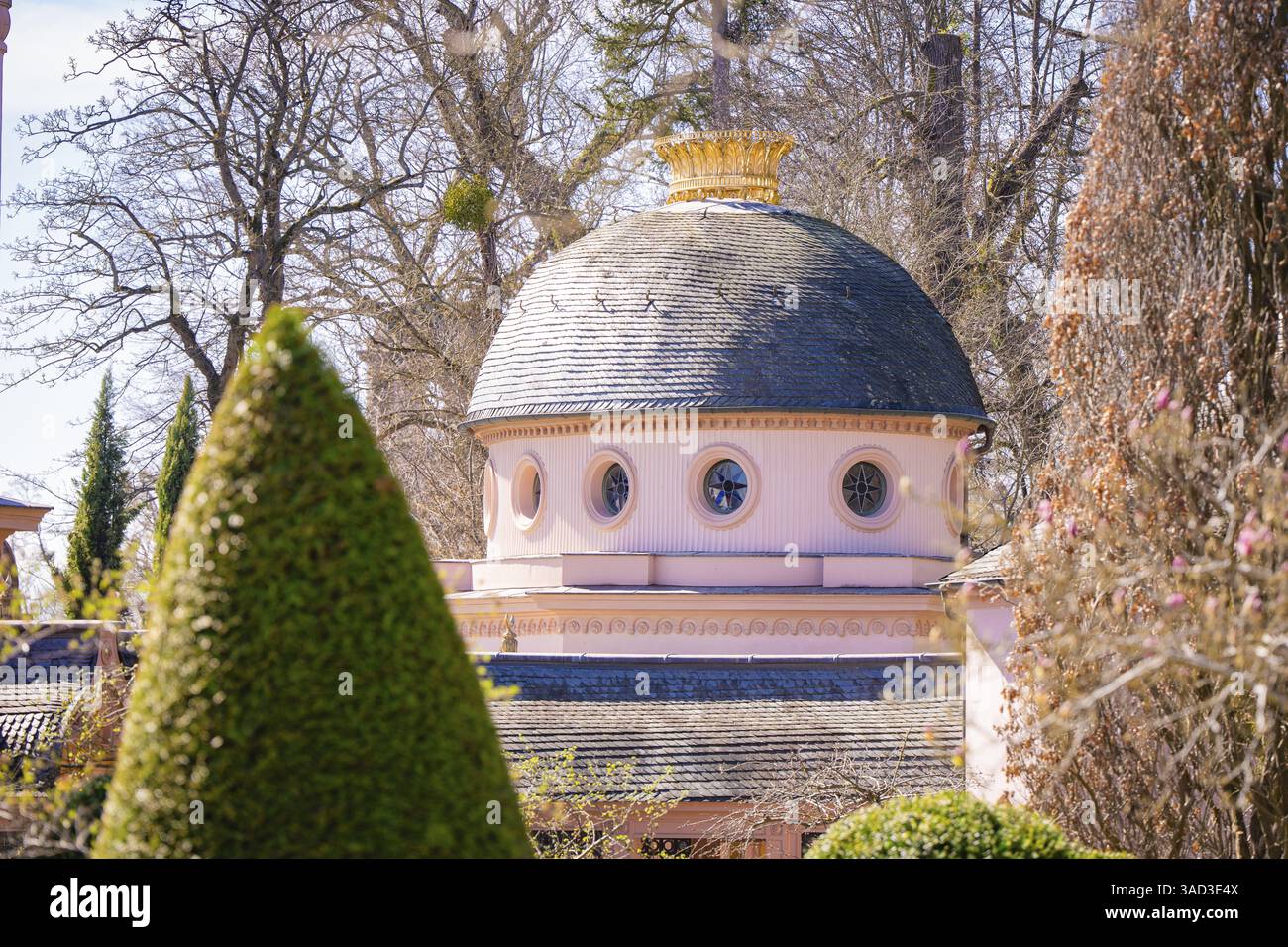 A historic dome with golden decorations surrounded by trees in spring ...