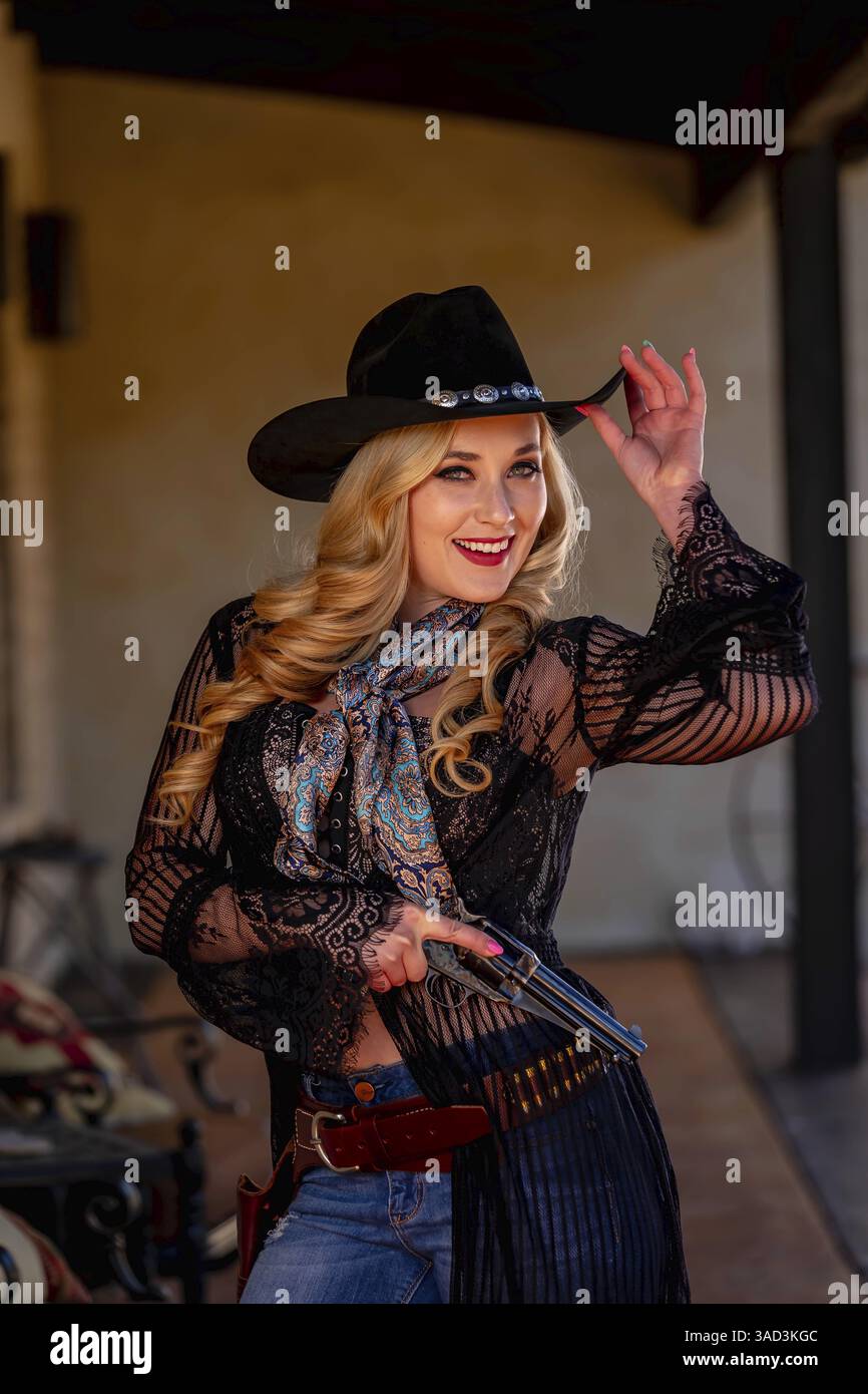 A confident, beautiful blonde woman in classic cowboy attire stands ...