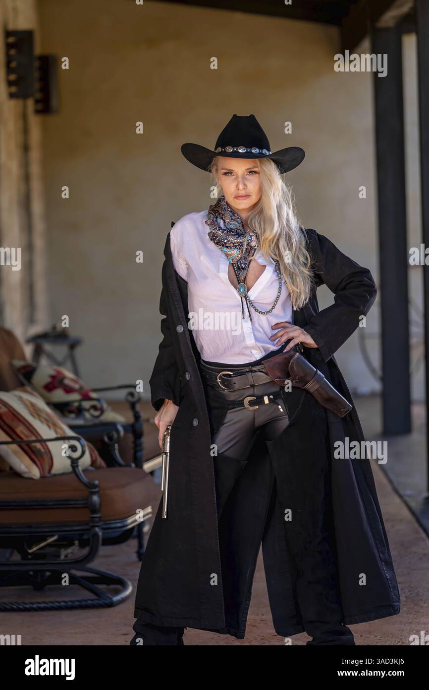 A confident, beautiful blonde woman in classic cowboy attire stands ...