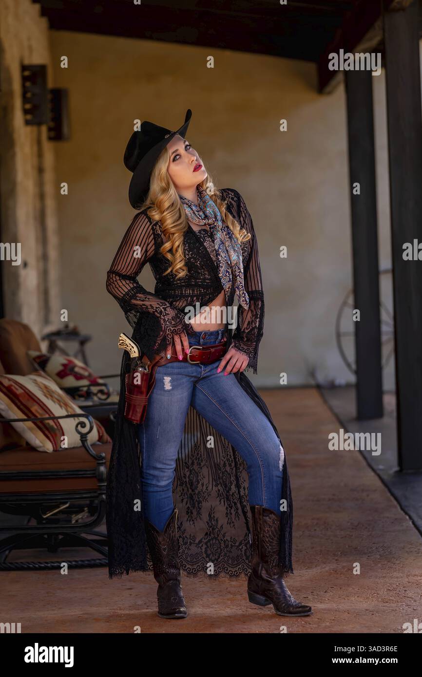 A confident, beautiful blonde woman in classic cowboy attire stands ...
