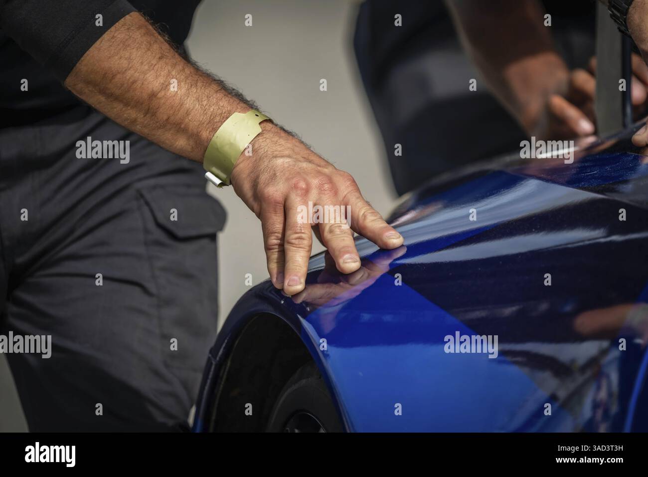 An engineer meticulously inspects the race car, fine-tuning key ...