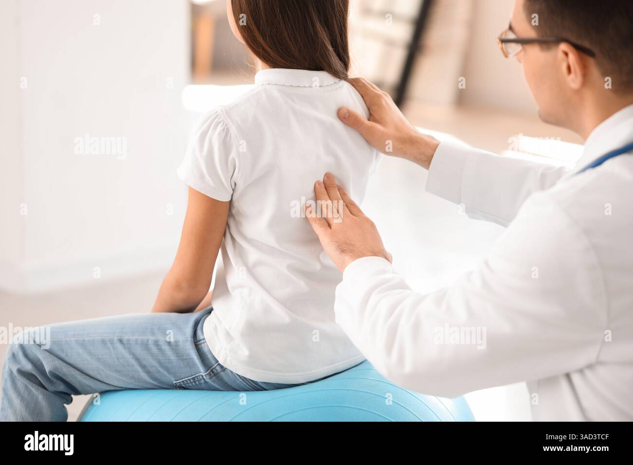 Doctor checking posture of little girl in clinic Stock Photo - Alamy